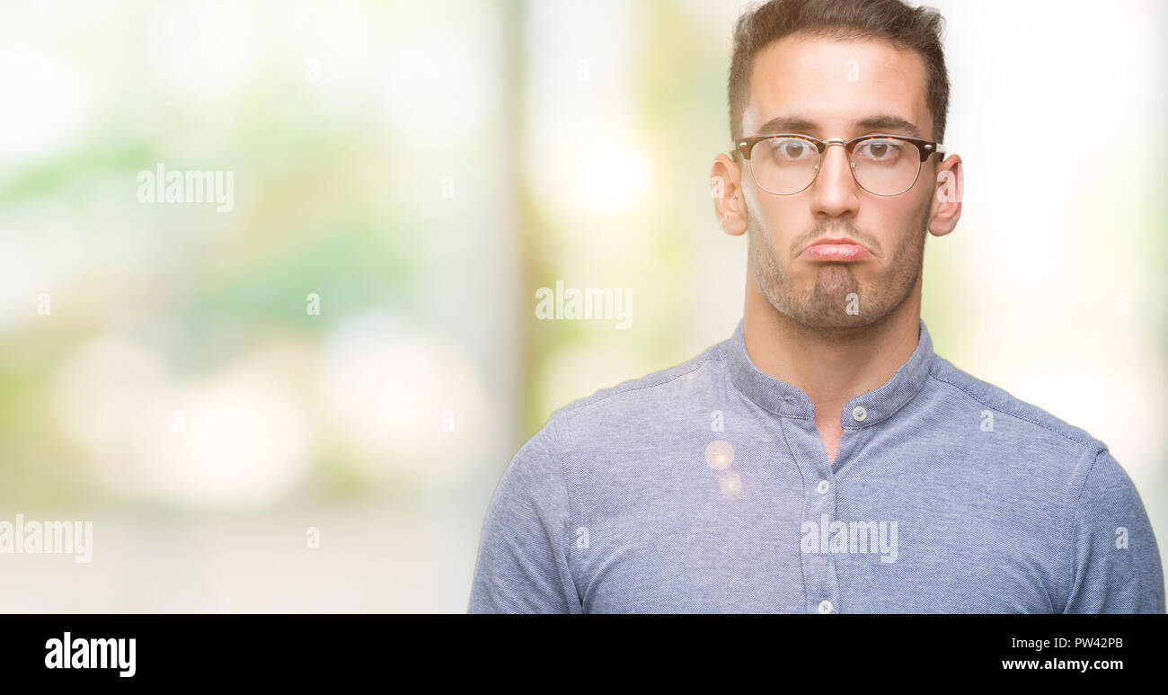 Handsome young elegant man wearing glasses depressed and worry for ...