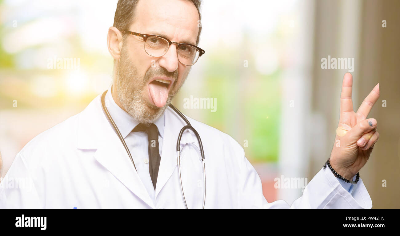 Doctor senior man, medical professional looking at camera showing tong ...
