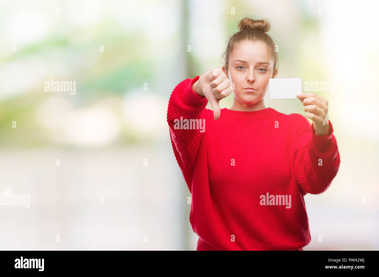 Young blonde woman holding advertising card with angry face, negative ...