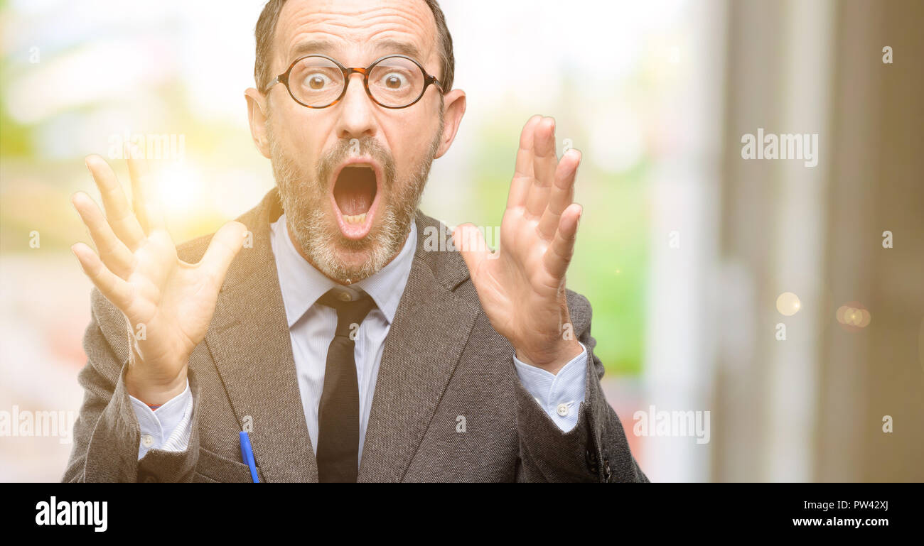 Teacher man using glasses stressful keeping hands on head, terrified in ...