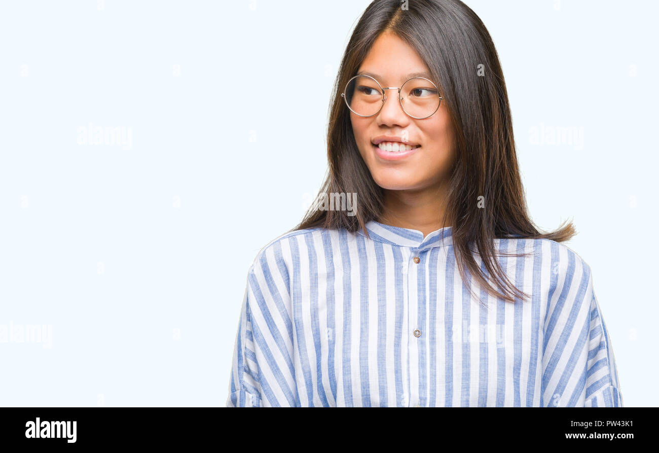 Young asian woman over isolated background looking away to side with ...