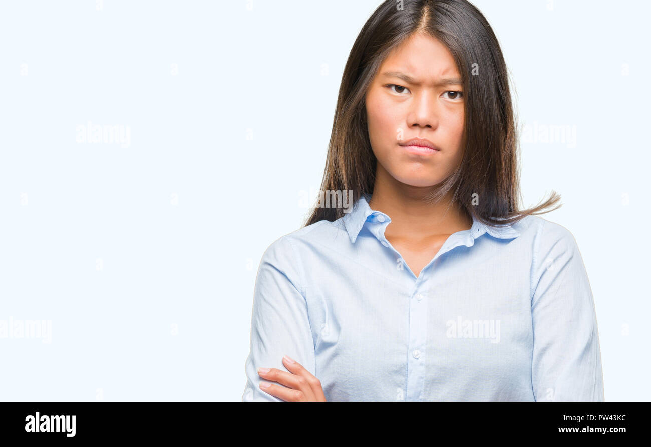 Young asian business woman over isolated background skeptic and nervous ...