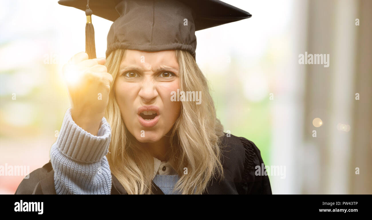 Young graduate woman irritated and angry expressing negative emotion ...