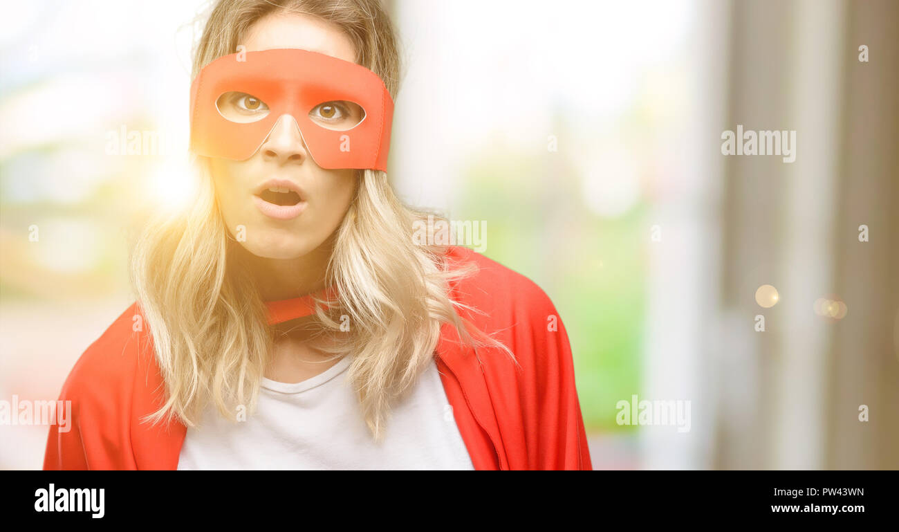 Young super hero woman wearing cape scared in shock, expressing panic ...