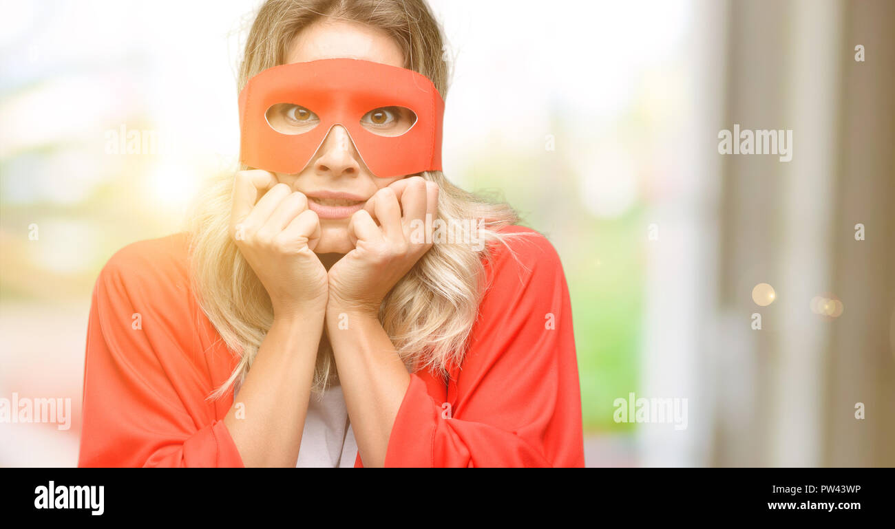 Young super hero woman wearing cape terrified and nervous expressing ...