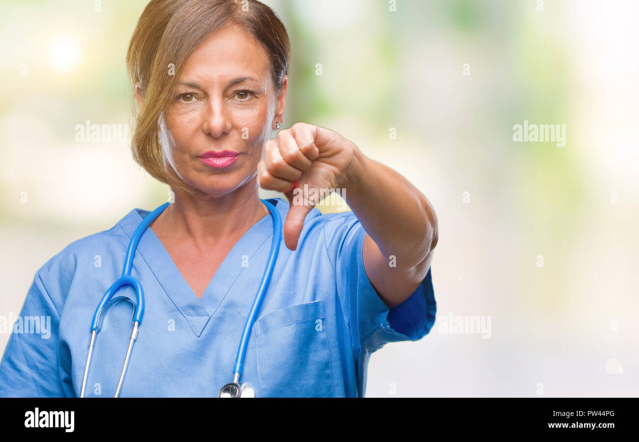 Middle age senior nurse doctor woman over isolated background looking ...