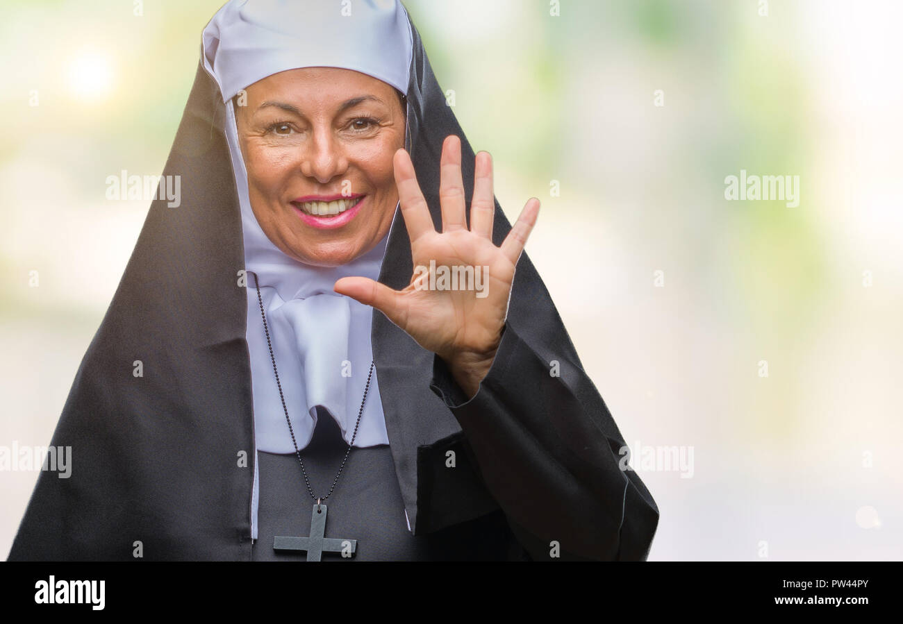 Middle age senior christian catholic nun woman over isolated background ...