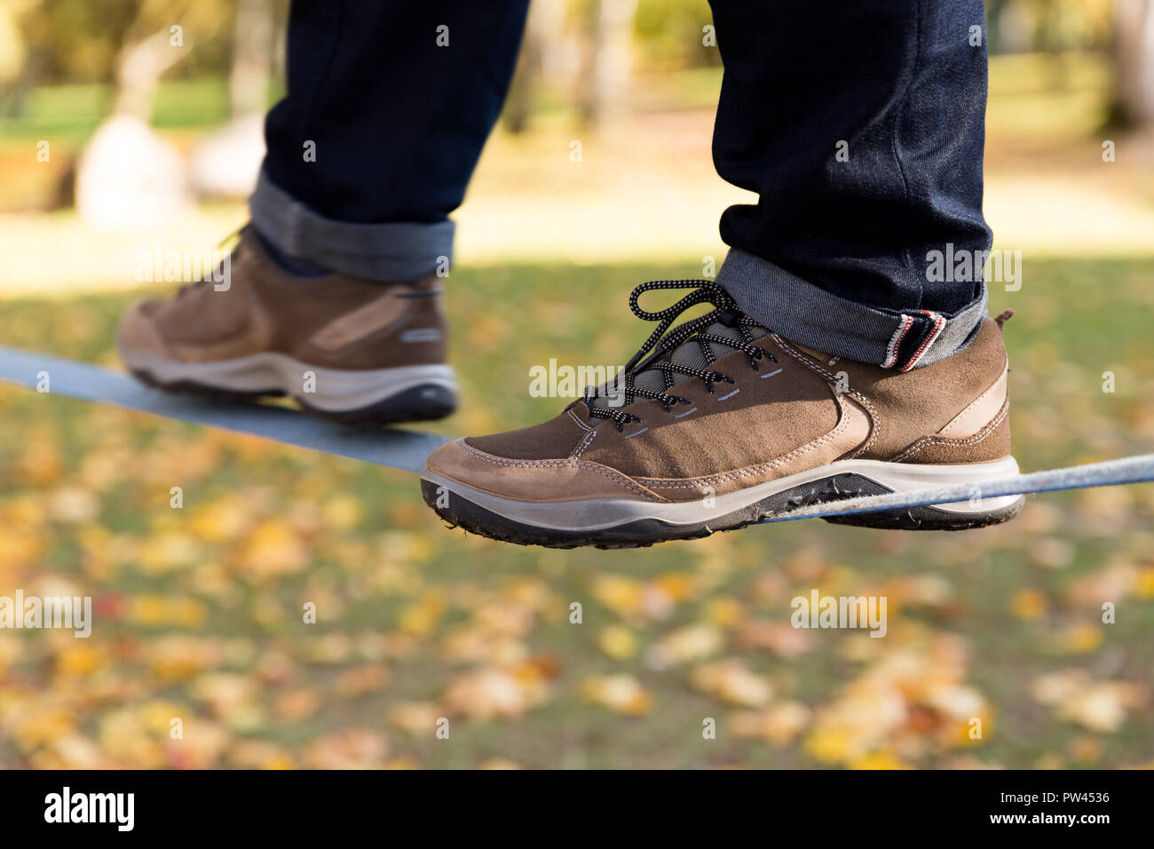 Walking over land on lanyard tied up between two trees. Colorful autumn ...