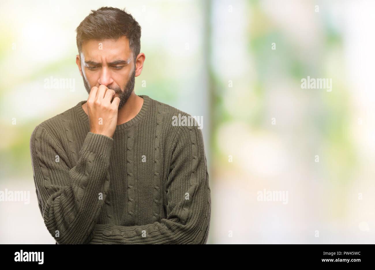 Adult hispanic man wearing winter sweater over isolated background ...