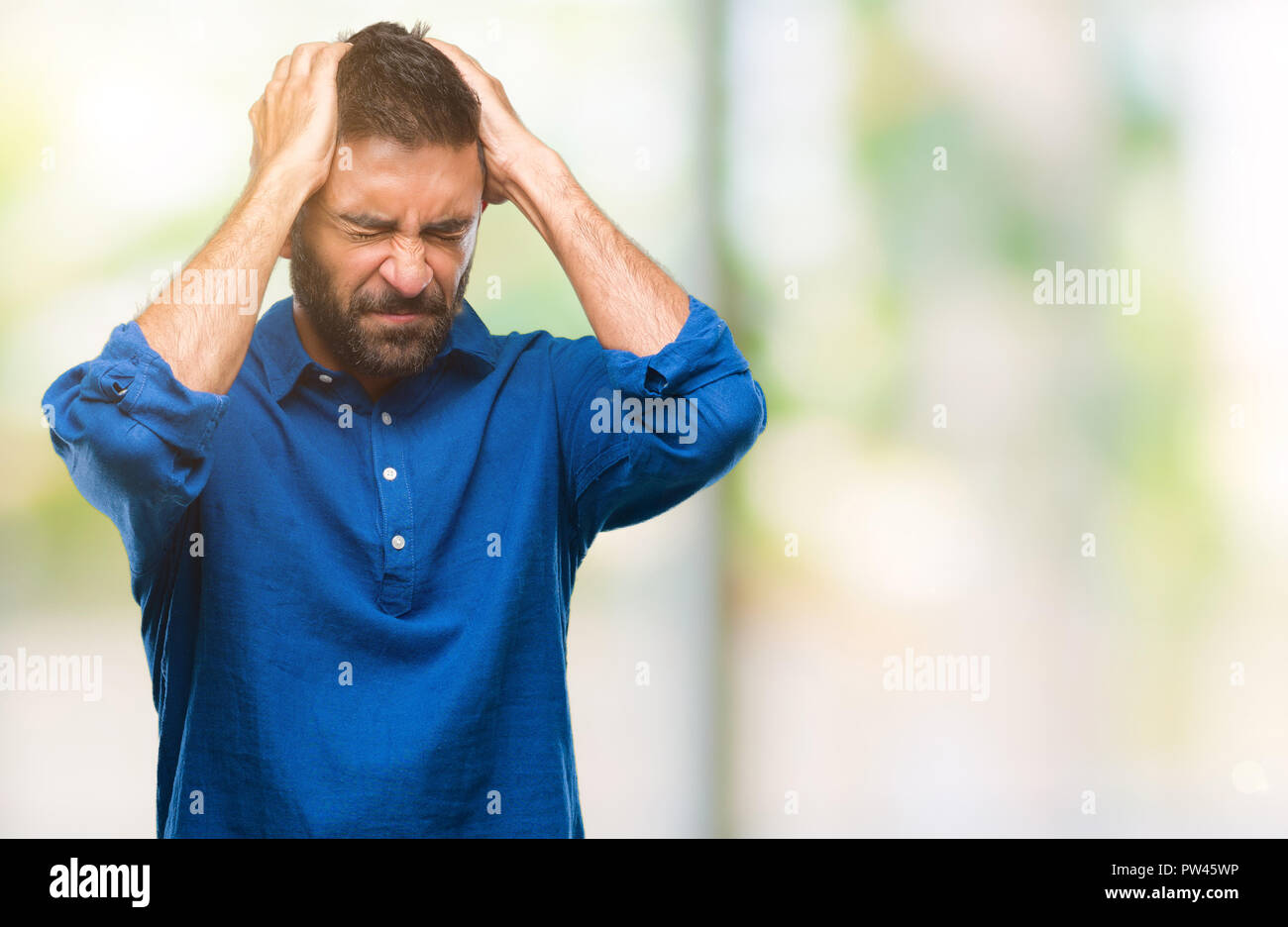 Adult hispanic man over isolated background suffering from headache ...