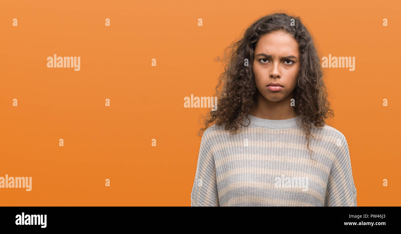 Beautiful young hispanic woman wearing stripes sweater skeptic and ...