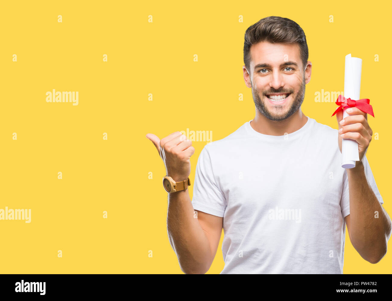 Young handsome man holding degree over isolated background pointing and ...