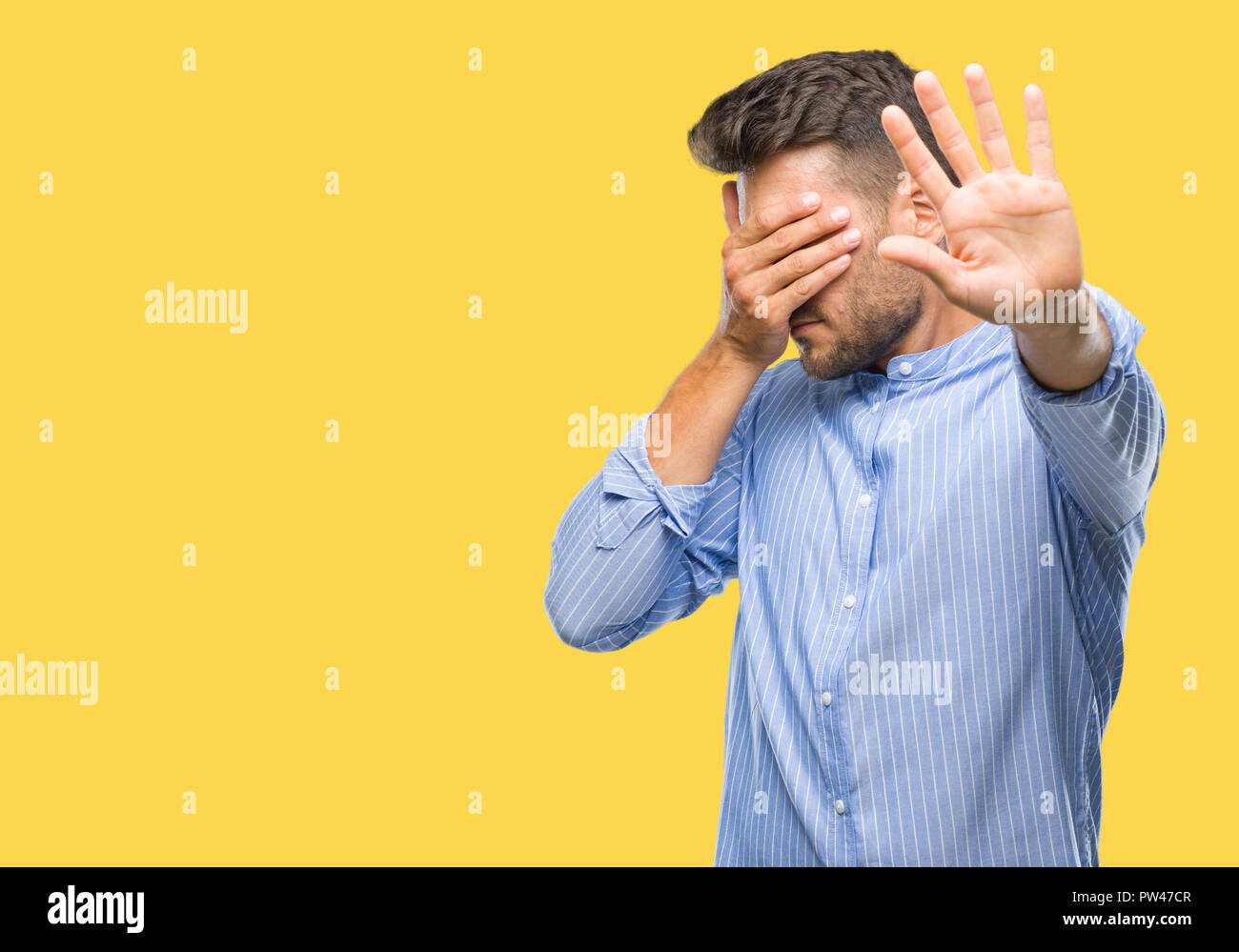 Young handsome man over isolated background covering eyes with hands ...