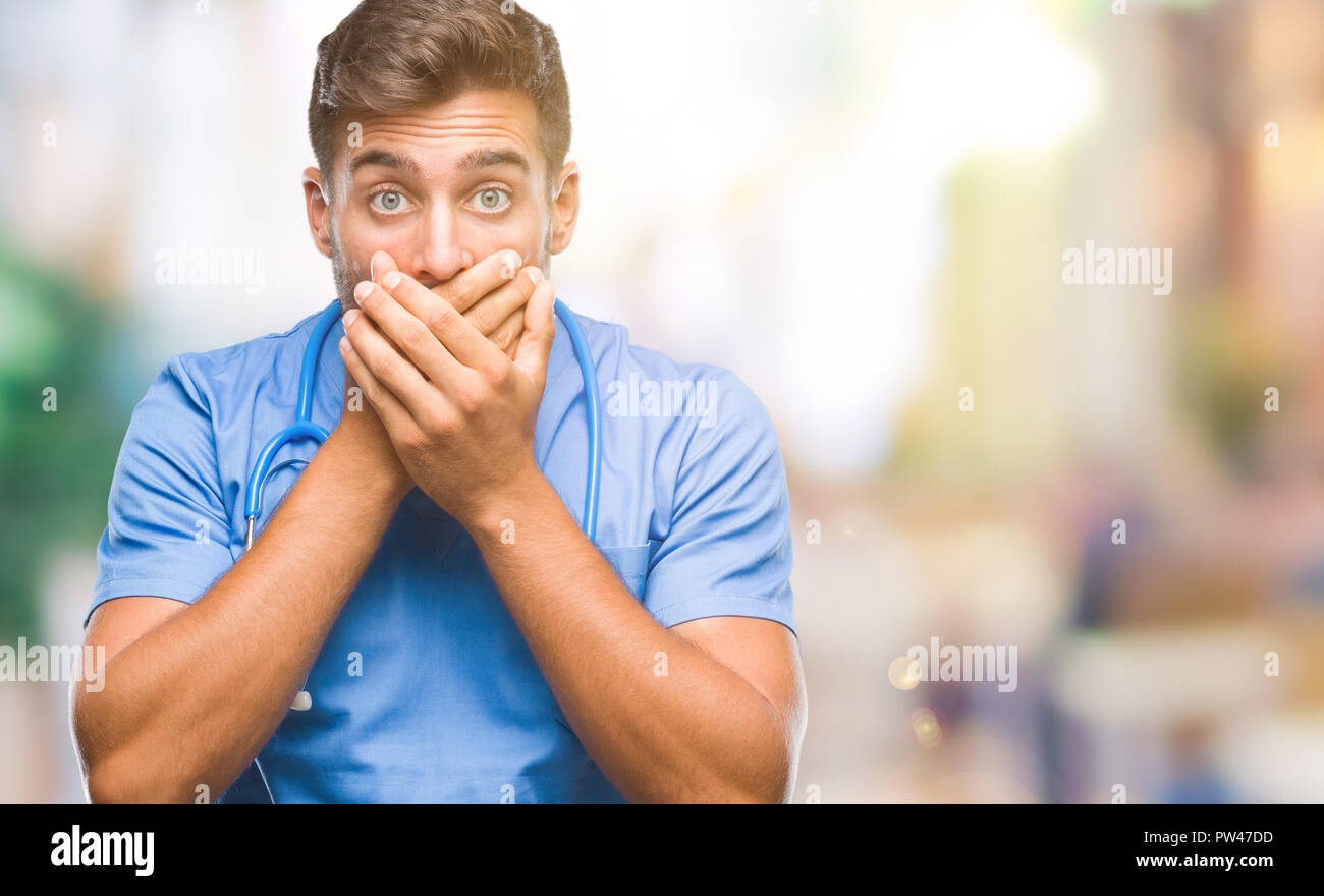 Young handsome doctor surgeon man over isolated background shocked ...