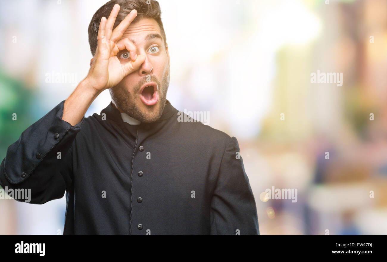 Young catholic christian priest man over isolated background doing ok ...