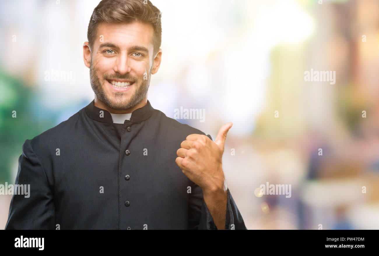 Young catholic christian priest man over isolated background smiling ...