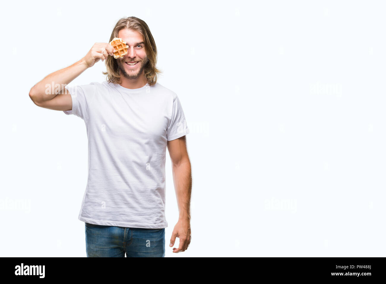 Young handsome man with long hair over isolated background eating ...
