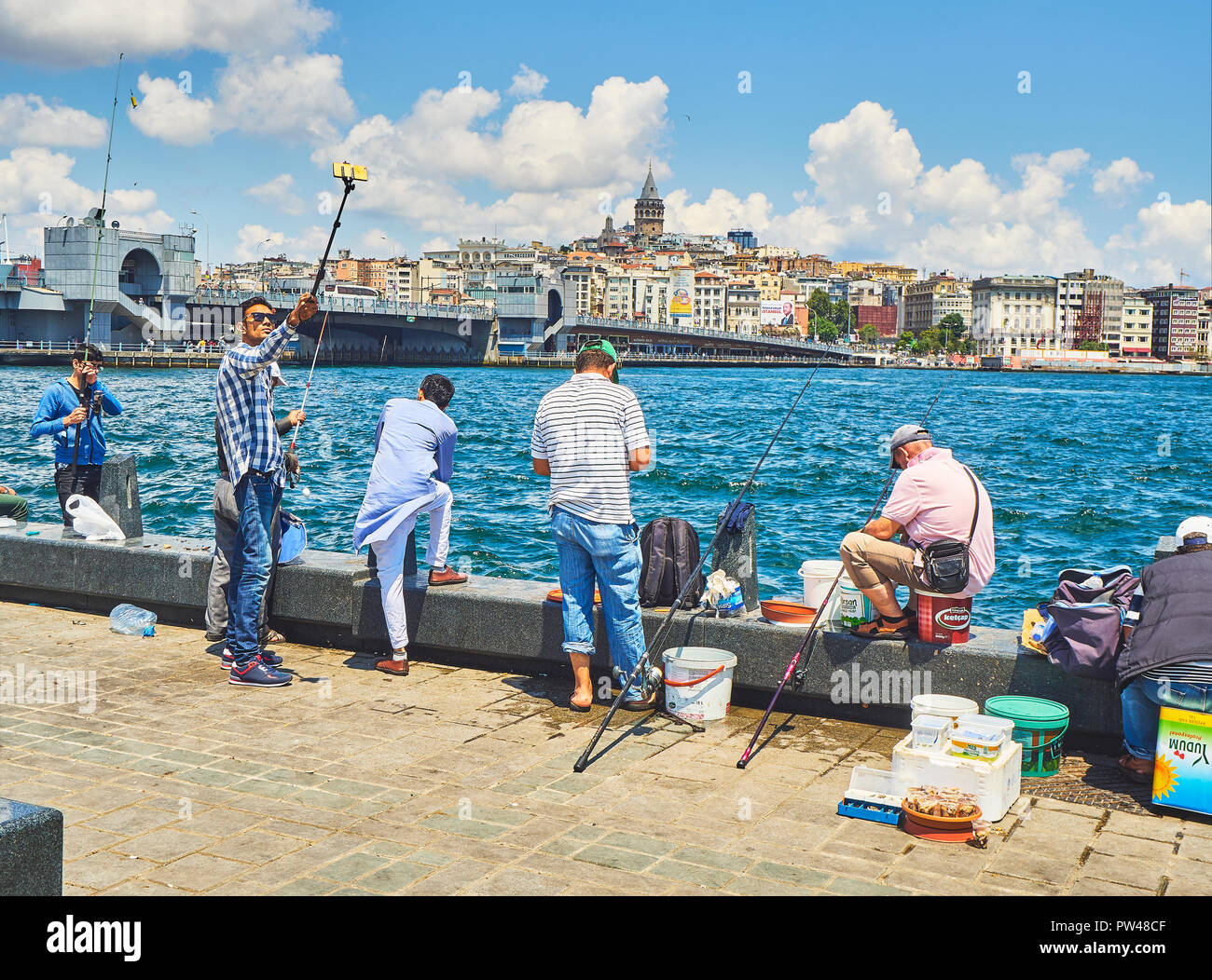Citizens fishing in Eminonu Pier with a view of the Karakoy district ...