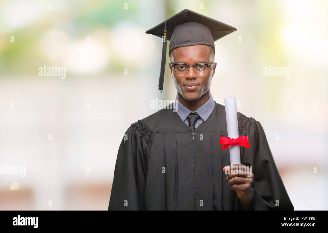 Young graduated african american man holding degree over isolated ...