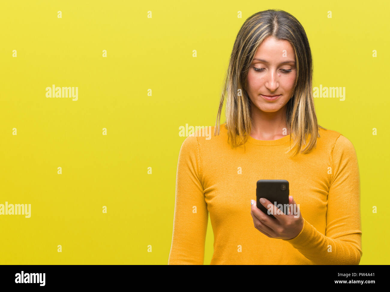 Young beautiful woman sending message using smartphone over isolated ...