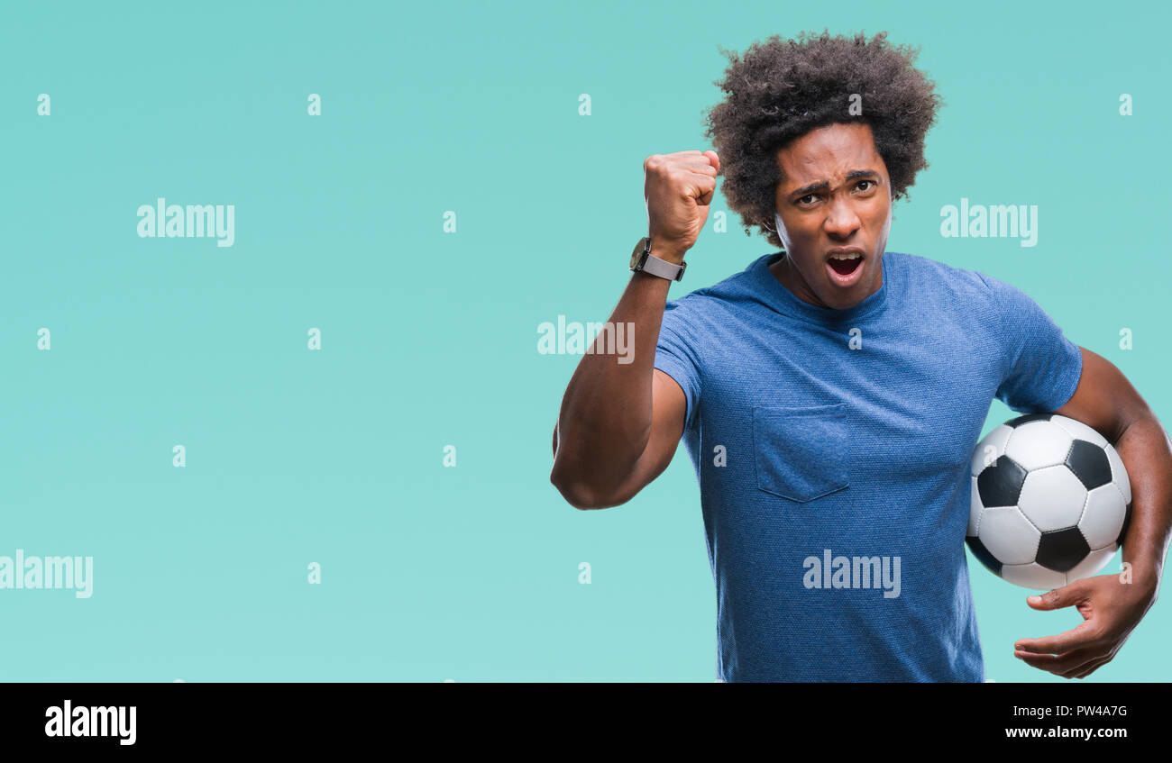 Afro american man holding football ball over isolated background ...