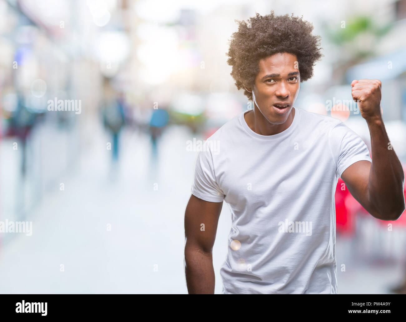Afro american man over isolated background angry and mad raising fist ...