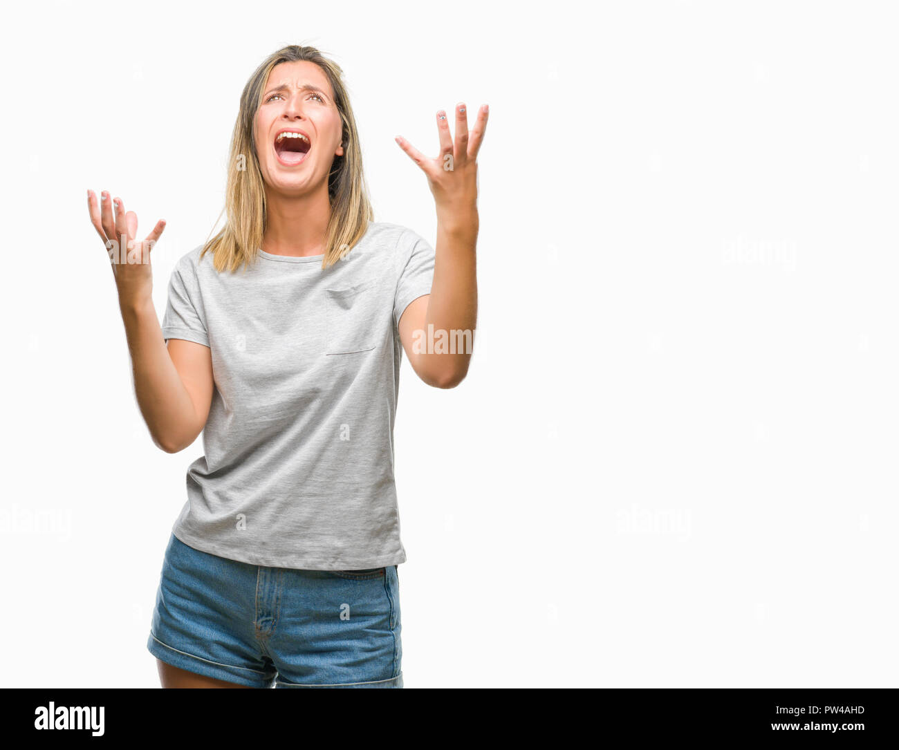 Young beautiful woman over isolated background crazy and mad shouting ...