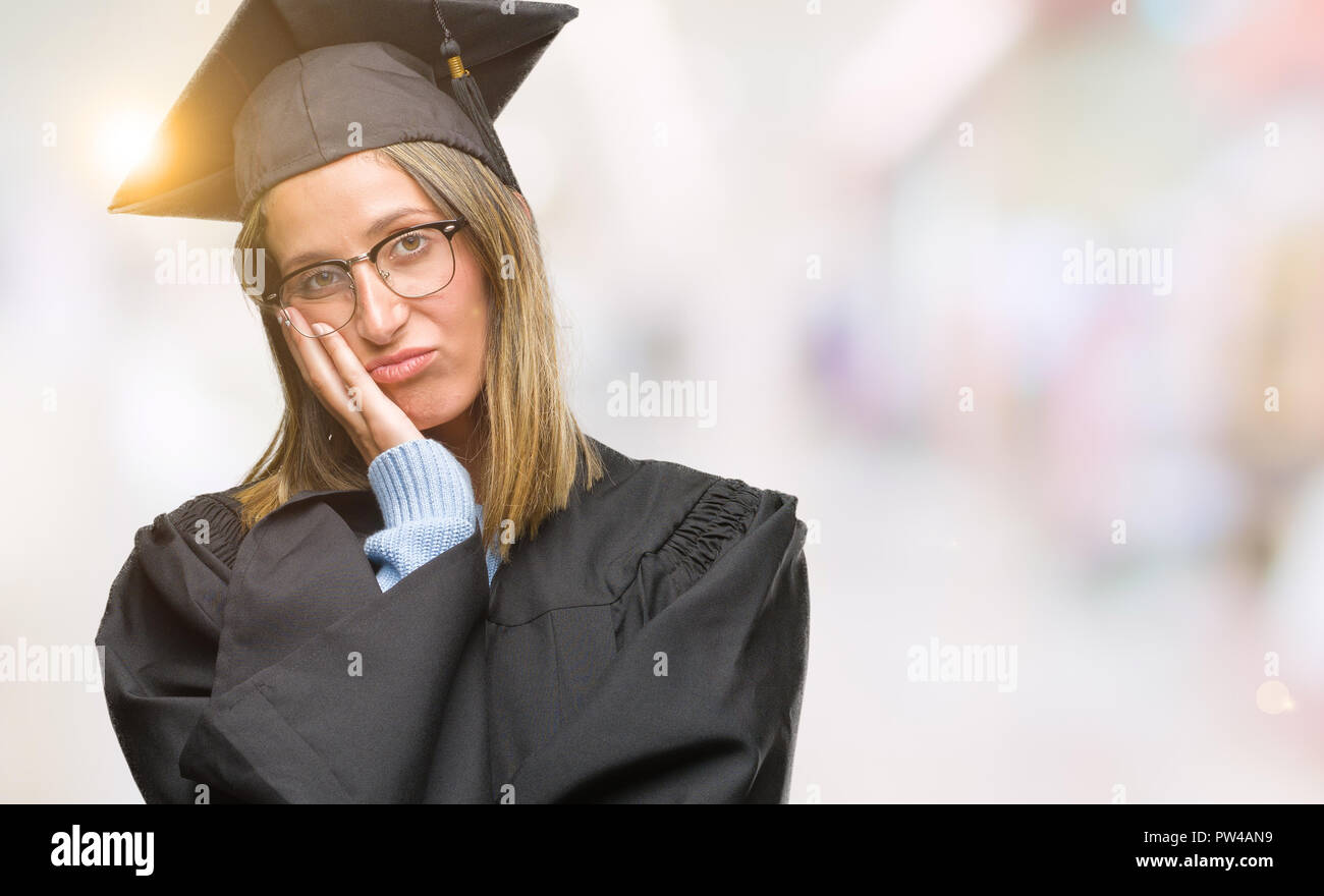 Young beautiful woman wearing graduated uniform over isolated ...