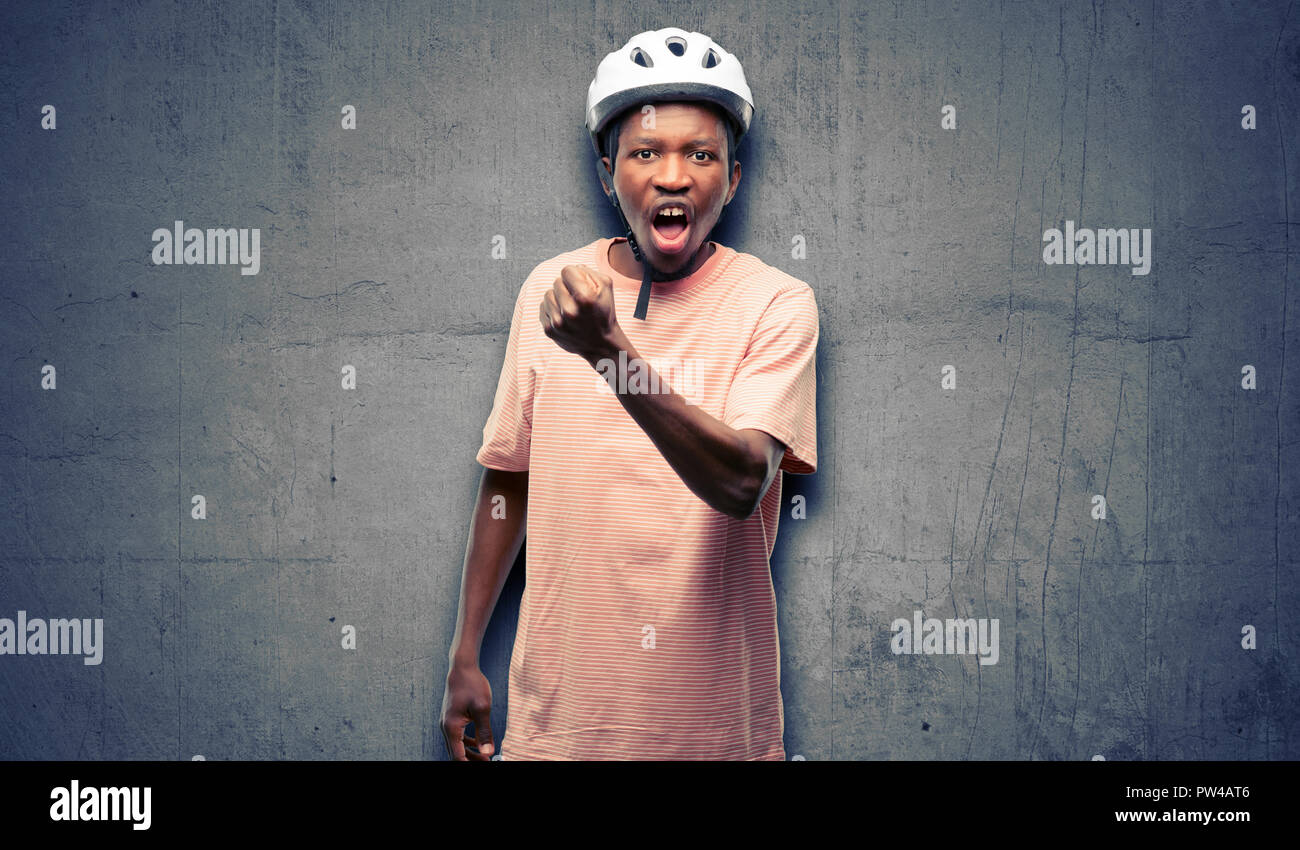 Black man wearing bike helmet irritated and angry expressing negative ...