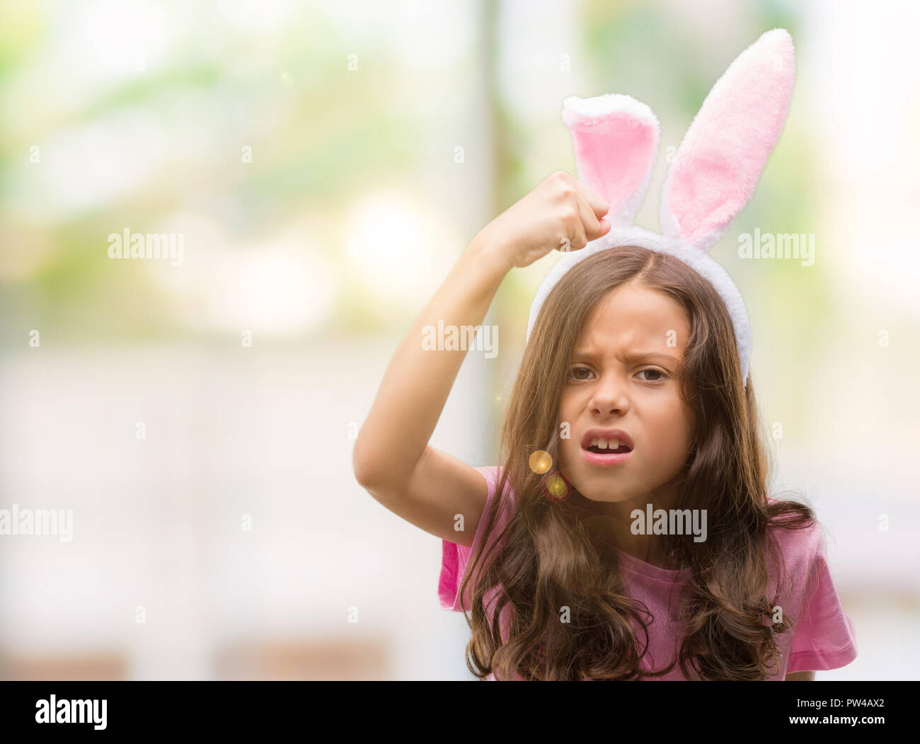 Brunette hispanic girl wearing easter rabbit ears annoyed and ...