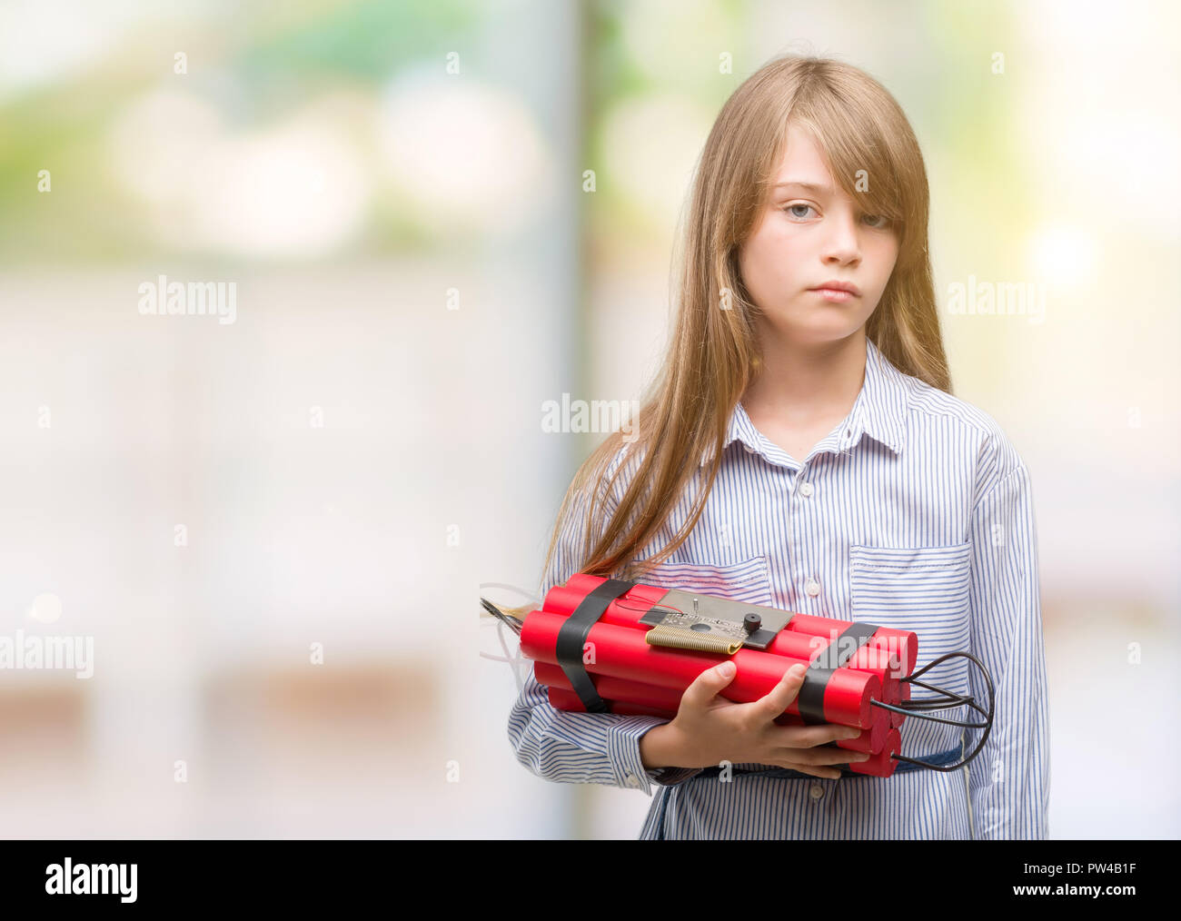 Young blonde child holding dynamite bomb with a confident expression on ...