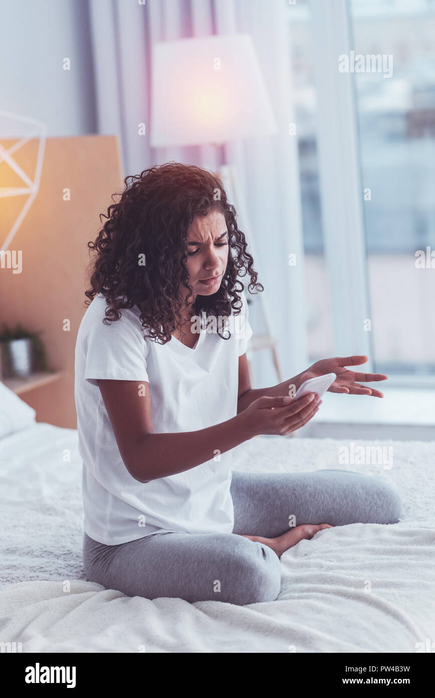 Woman feeling curious reading unexpected message from boyfriend Stock ...