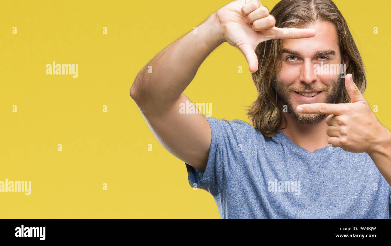 Young handsome man with long hair over isolated background smiling ...