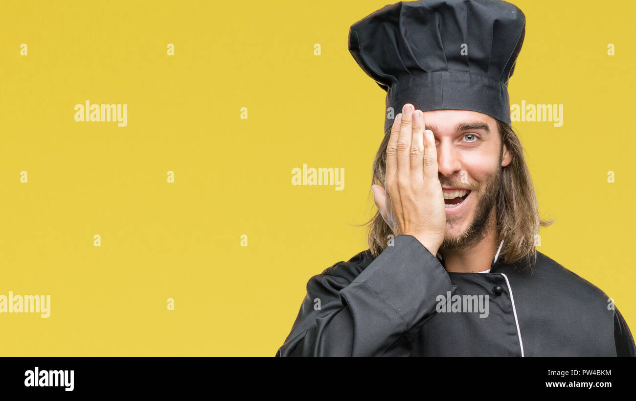 Young handsome cook man with long hair over isolated background ...