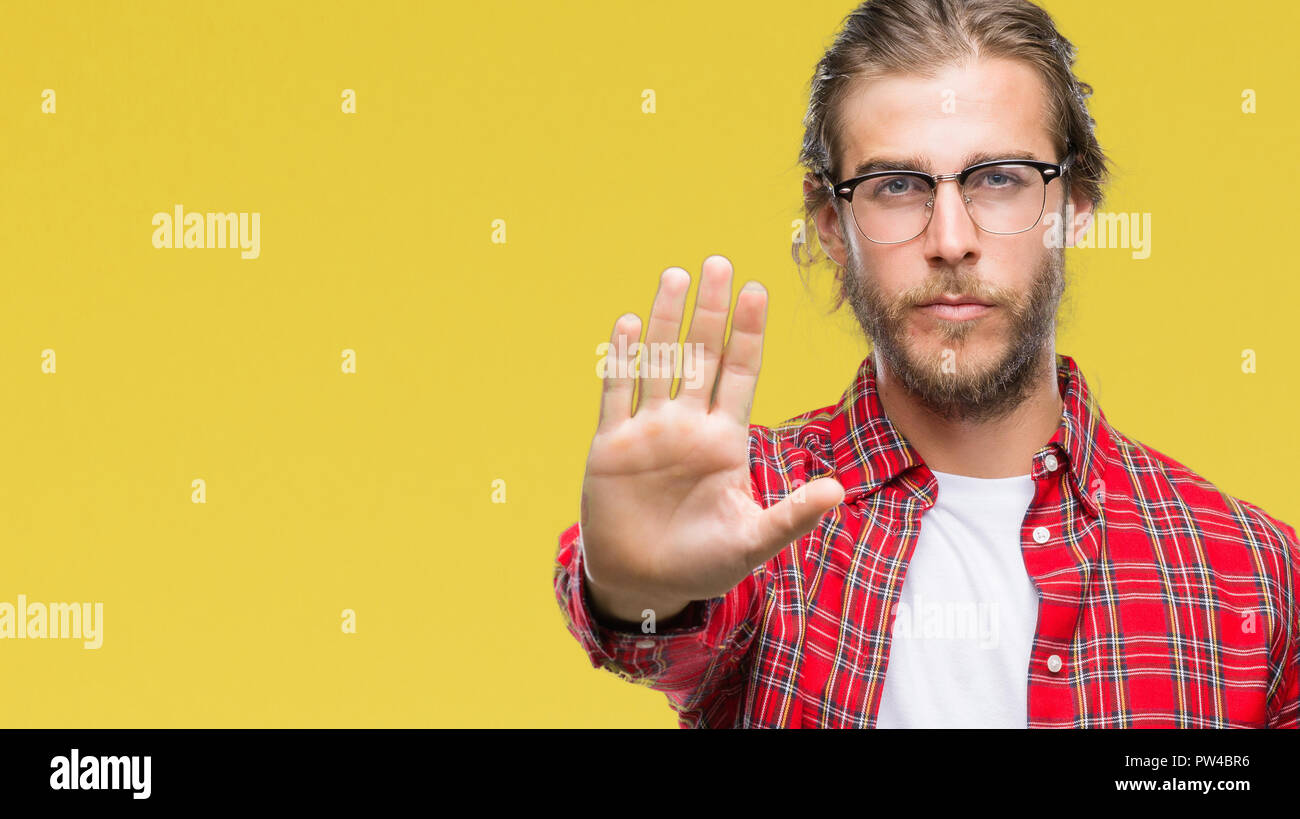 Young handsome man with long hair wearing glasses over isolated ...