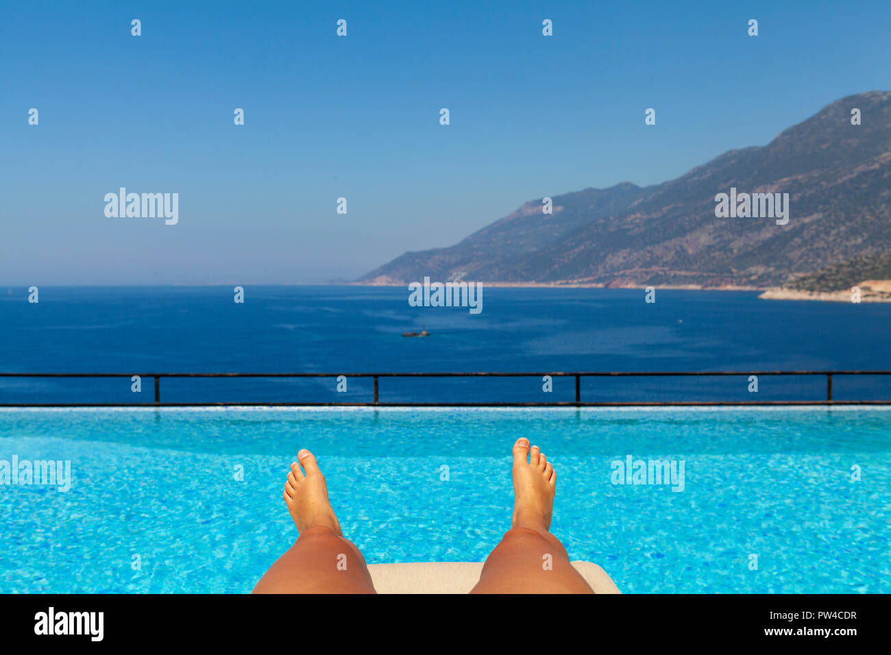 Sunbathing with a view of a pool and the sea Stock Photo - Alamy