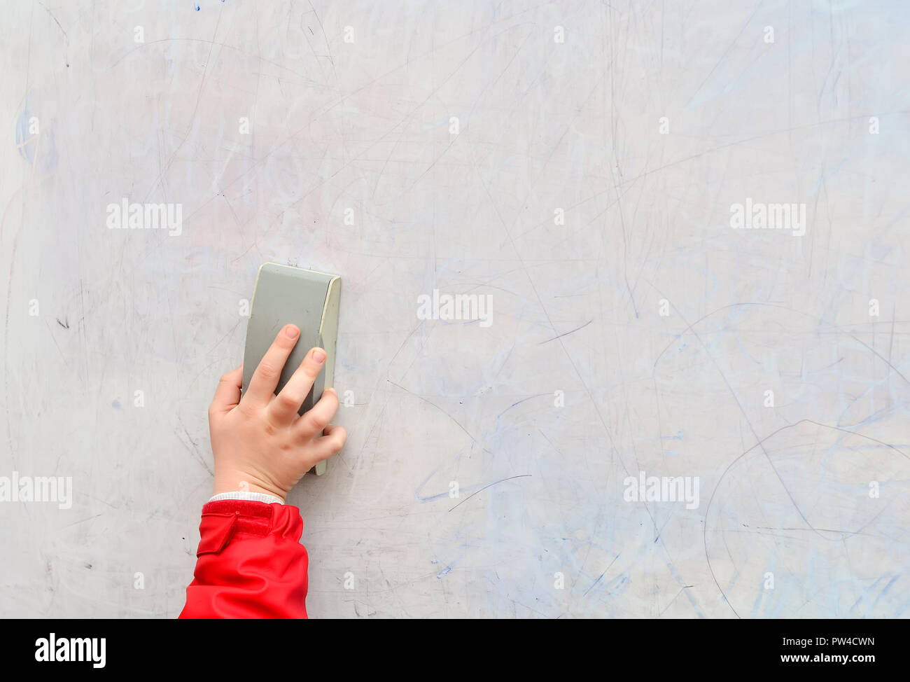 schoolgirl hand erases on blackboard with board eraser in classroom ...