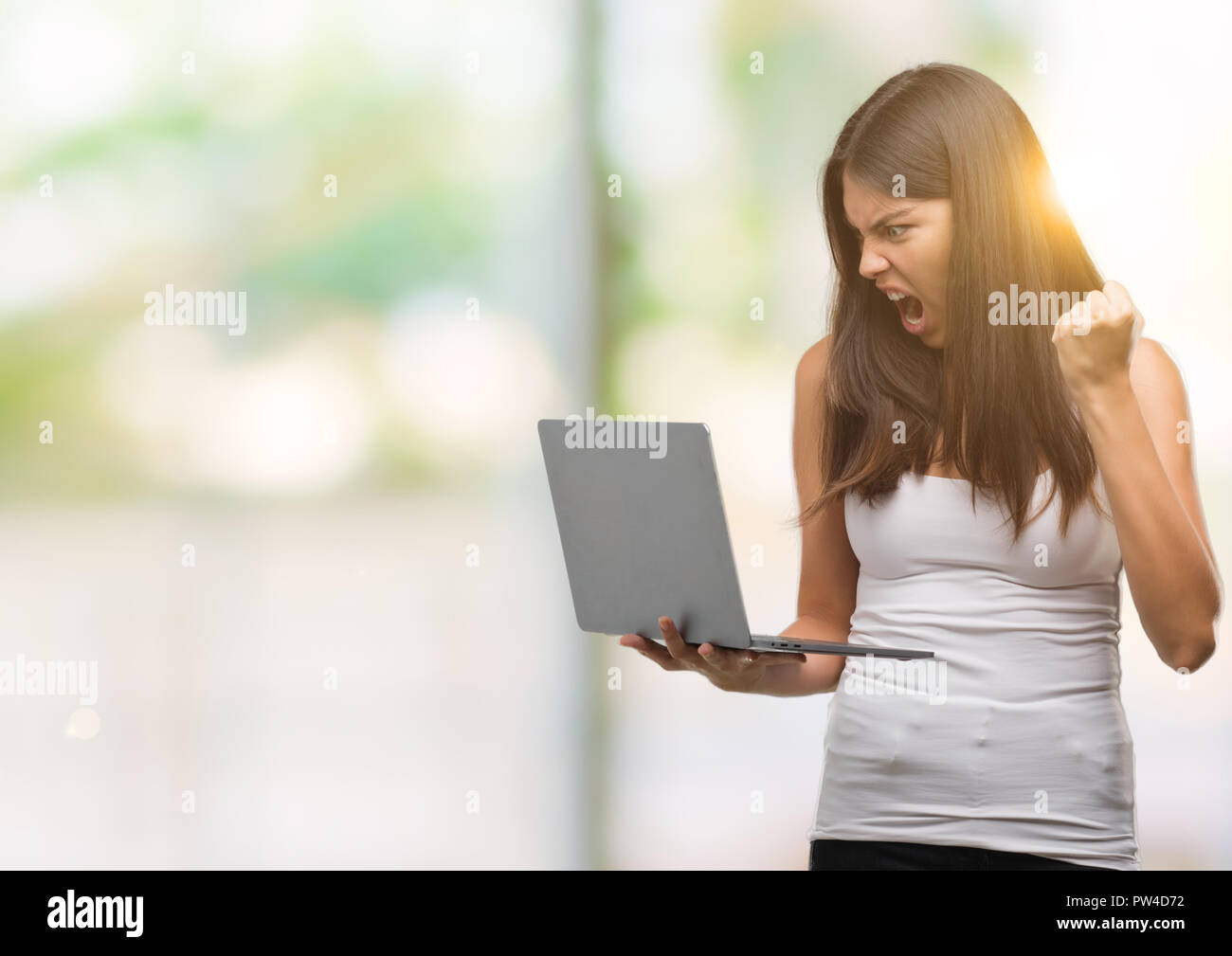 Young hispanic woman using computer laptop annoyed and frustrated ...