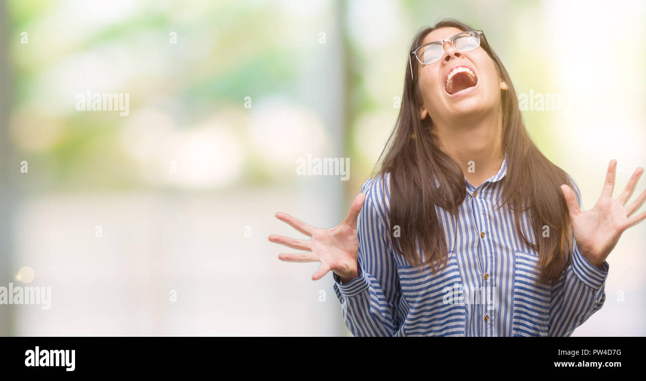 Young beautiful hispanic business woman crazy and mad shouting and ...