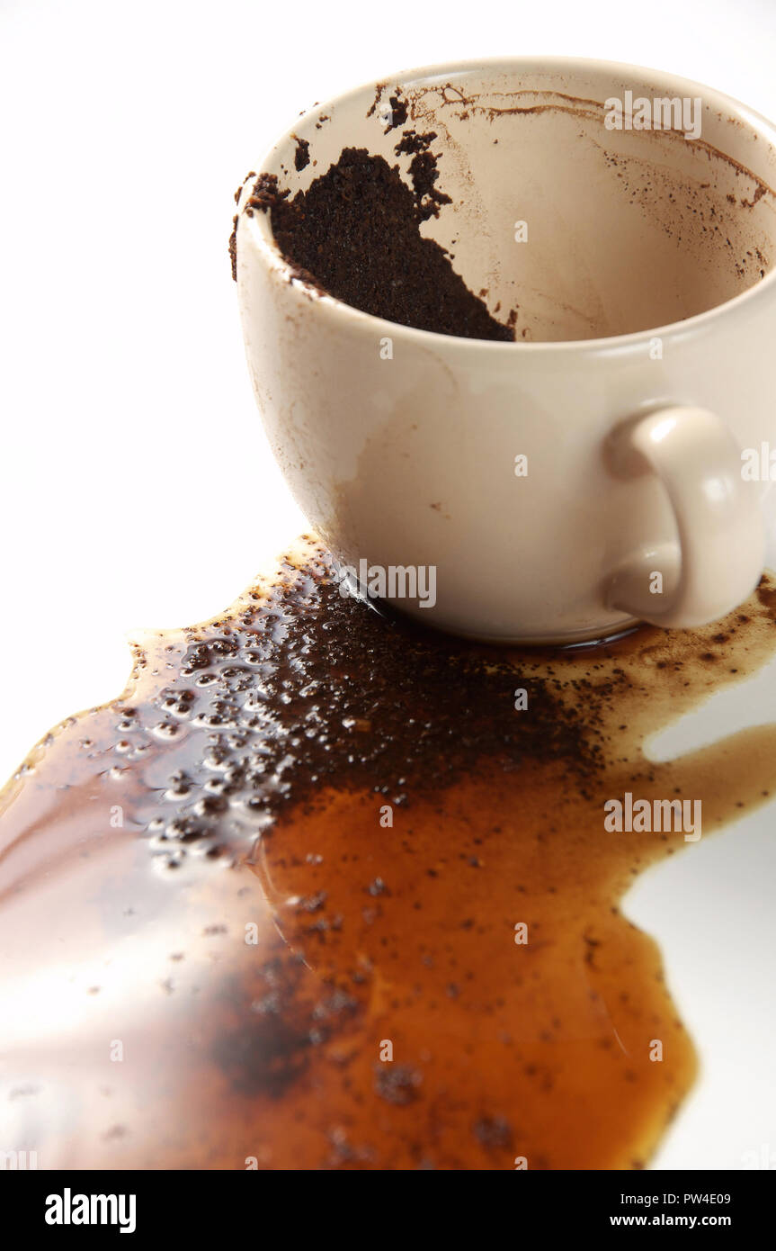 Spilled coffee and coffee grounds on a white background. Cup of coffee ...