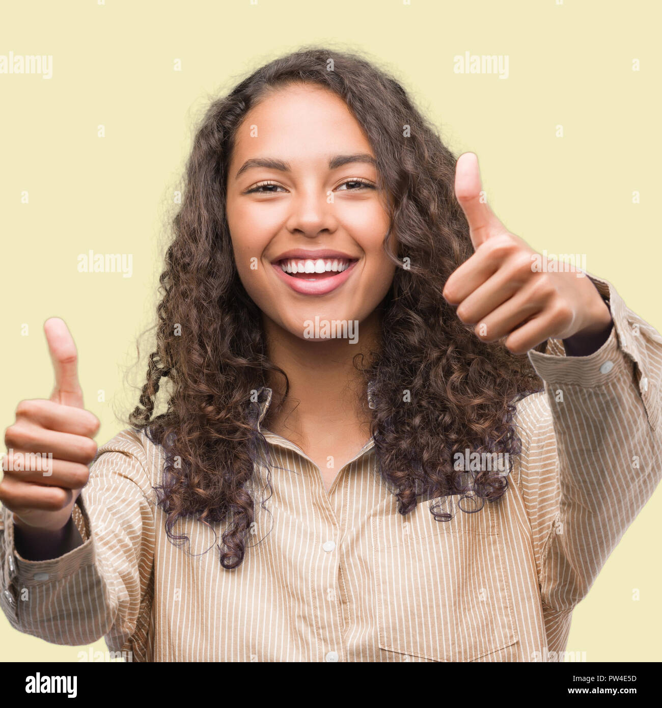 Young hispanic business woman approving doing positive gesture with ...