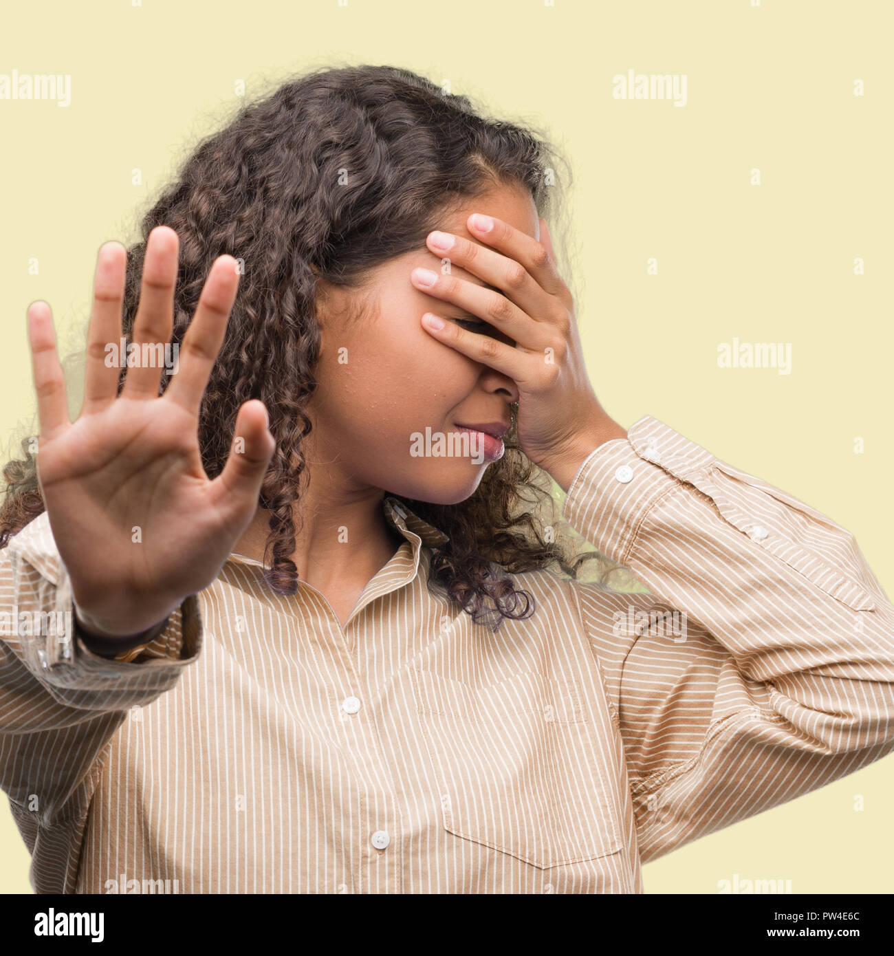 Young hispanic business woman covering eyes with hands and doing stop ...
