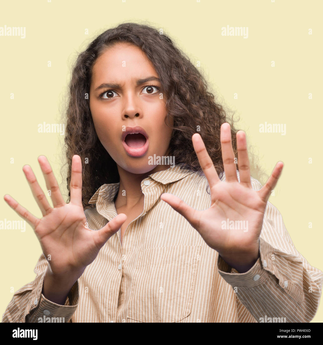 Young hispanic business woman afraid and terrified with fear expression ...