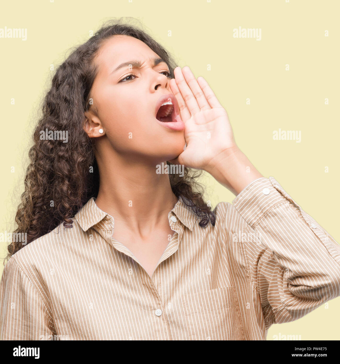 Young hispanic business woman shouting and screaming loud to side with ...