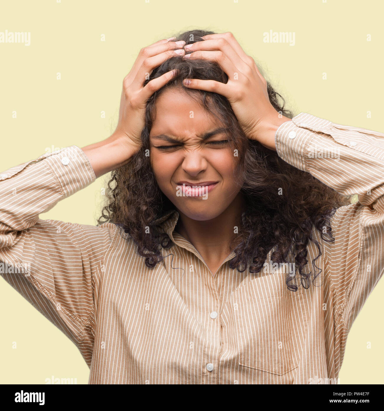 Young hispanic business woman suffering from headache desperate and ...