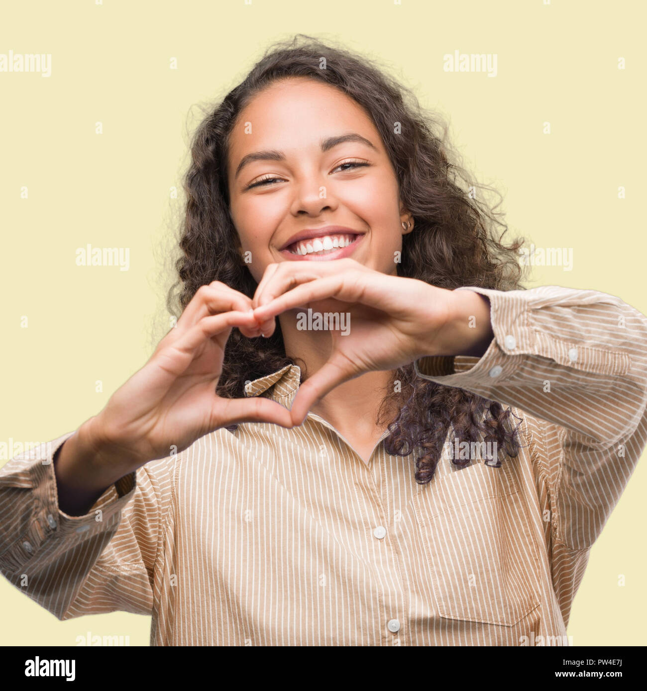 Young hispanic business woman smiling in love showing heart symbol and ...