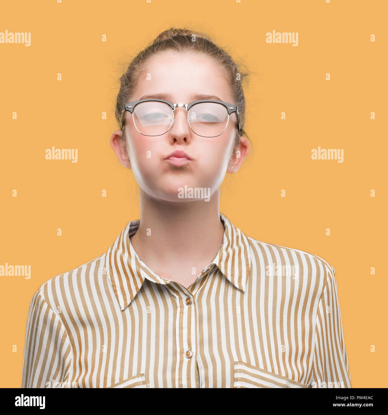 Young blonde business woman puffing cheeks with funny face. Mouth ...