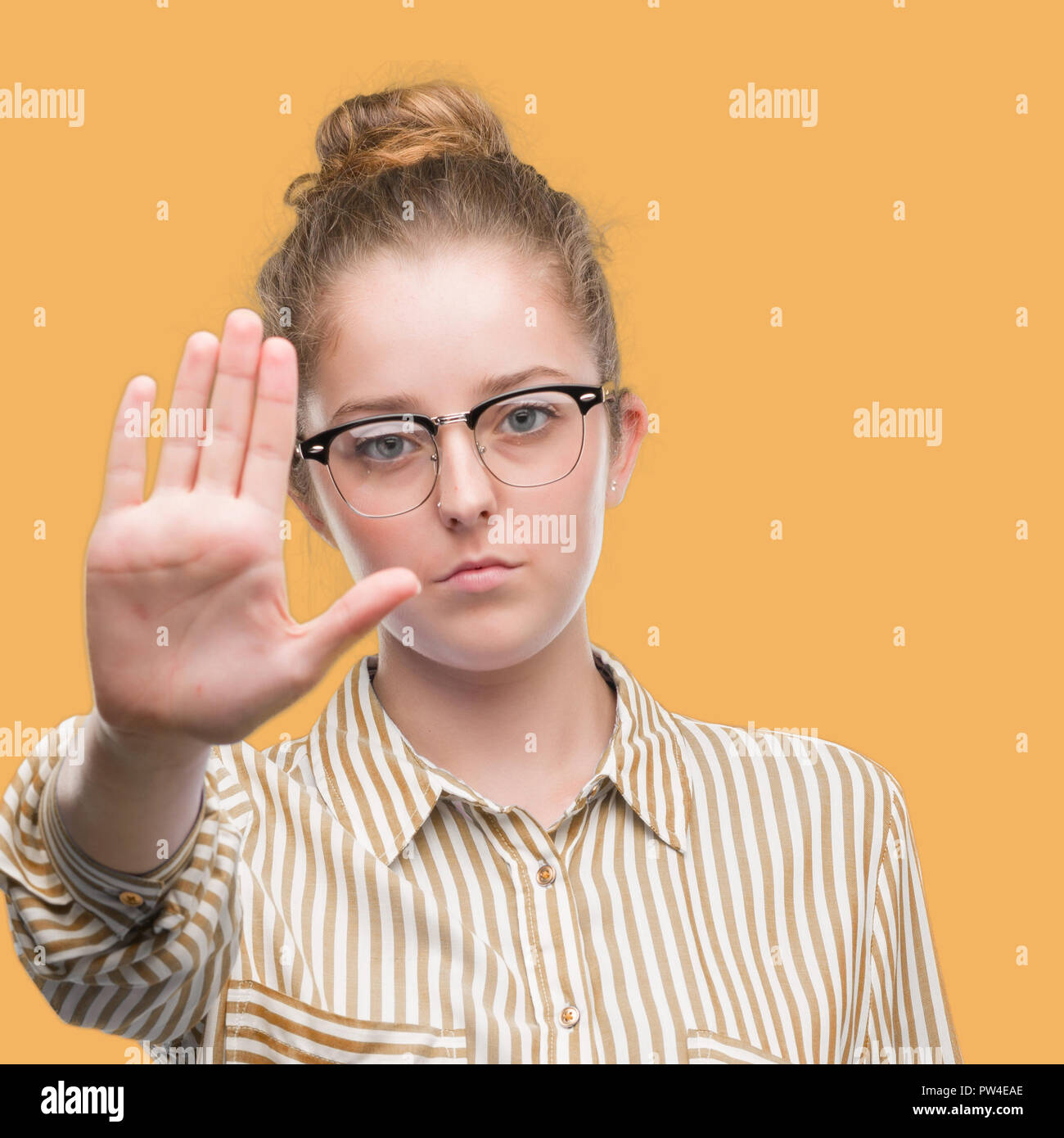 Young blonde business woman doing stop sing with palm of the hand ...