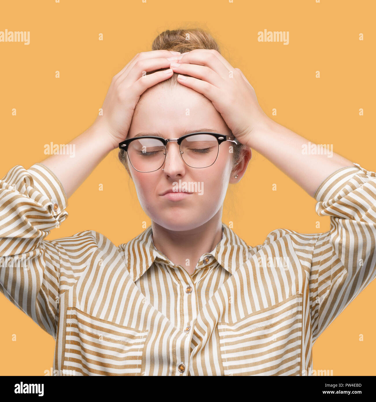 Young blonde business woman suffering from headache desperate and ...