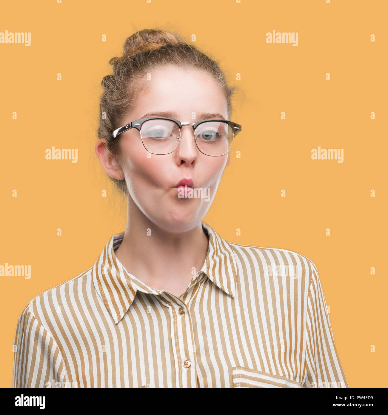 Young blonde business woman making fish face with lips, crazy and ...